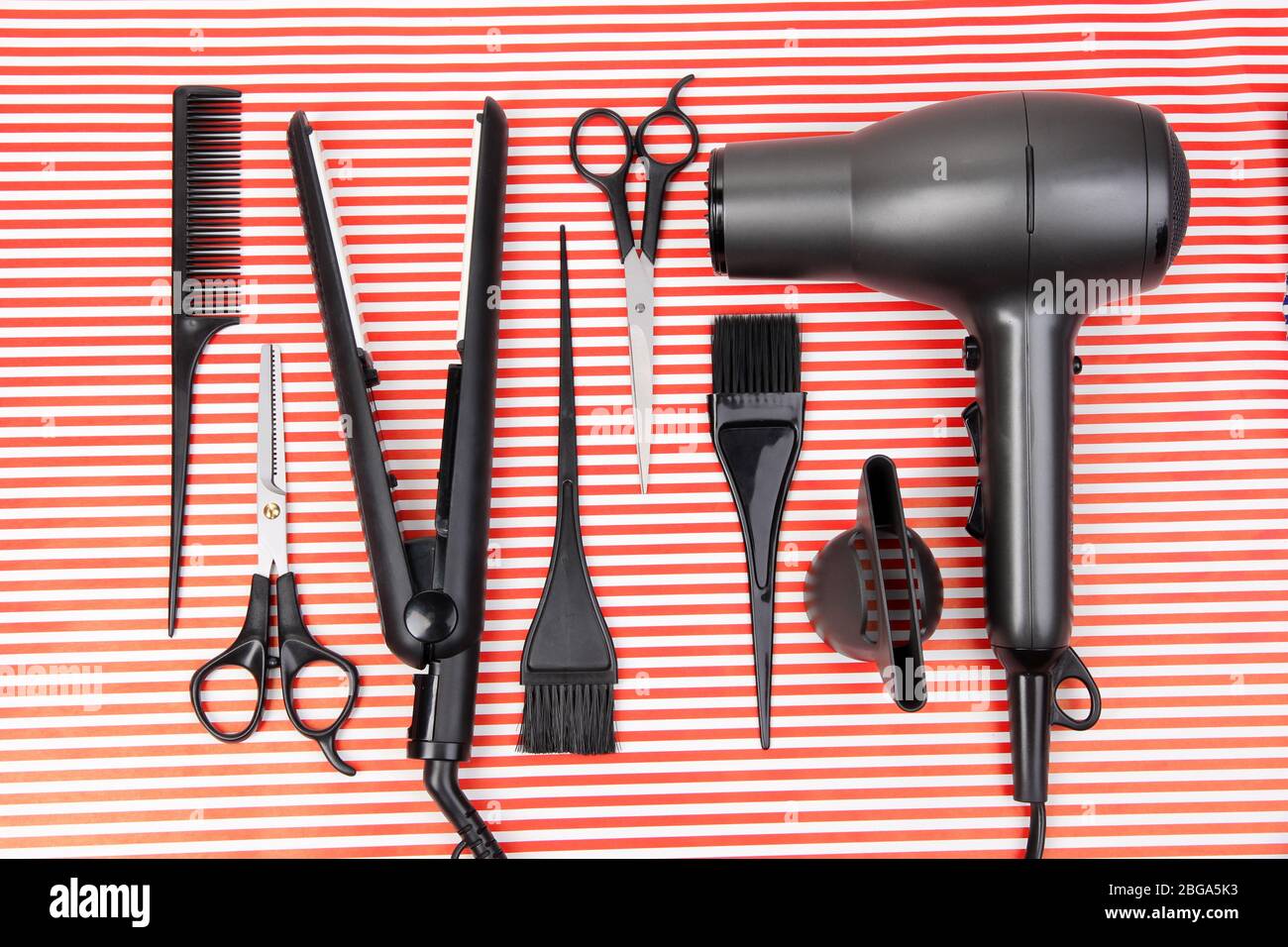 Hairdressing tools on striped red background Stock Photo - Alamy