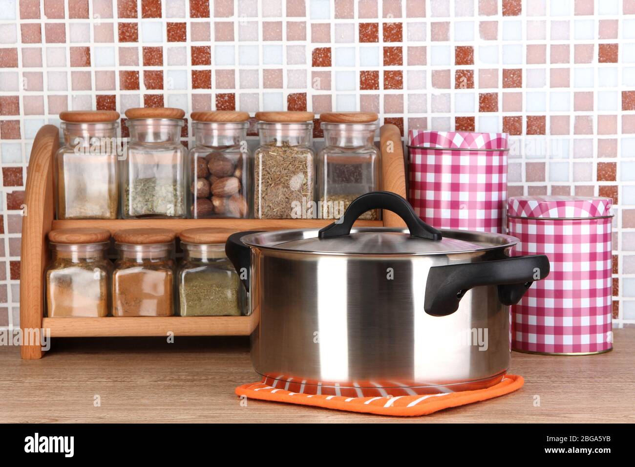 Pot and spices in kitchen on table on mosaic tiles background Stock ...