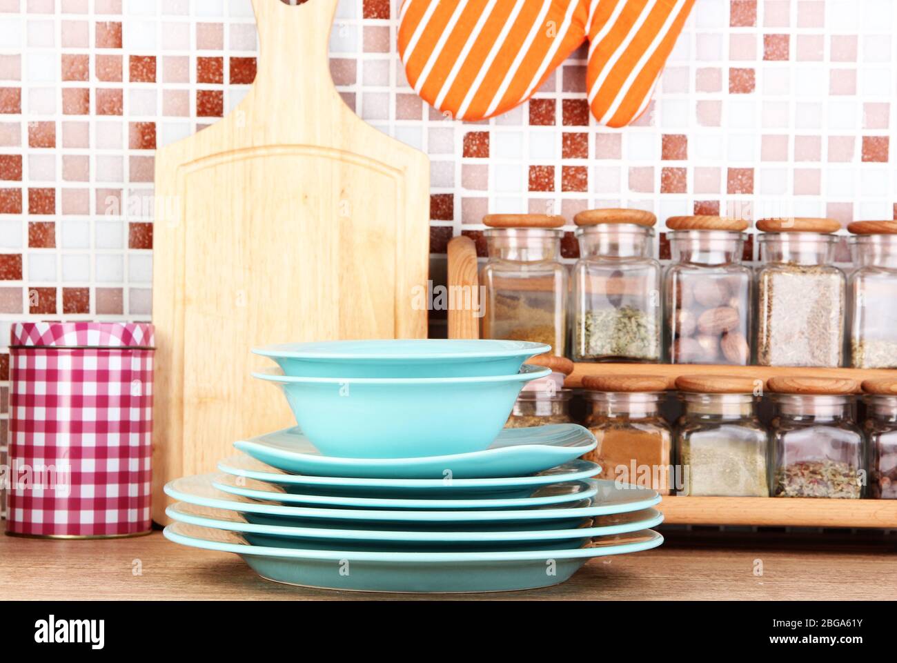 Plates in kitchen on table on mosaic tiles background Stock Photo - Alamy