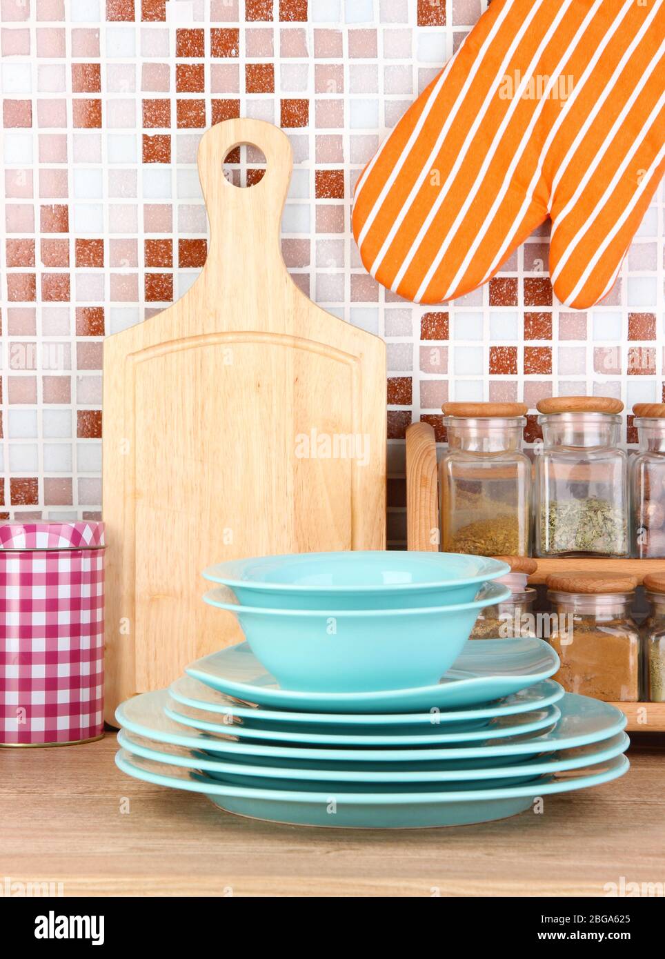 Plates in kitchen on table on mosaic tiles background Stock Photo - Alamy
