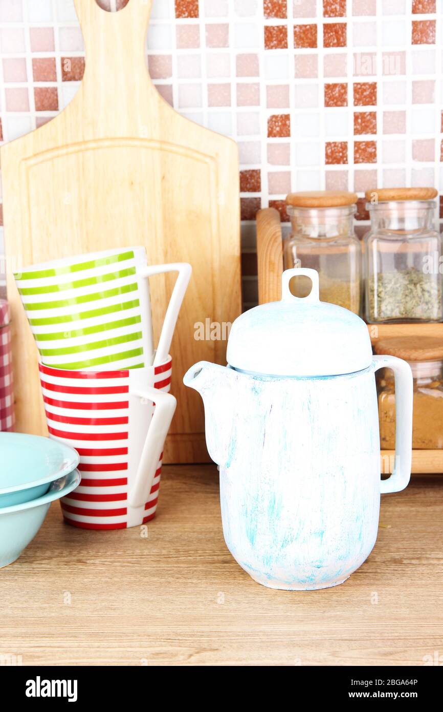 Tableware in kitchen on table on mosaic tiles background Stock Photo ...