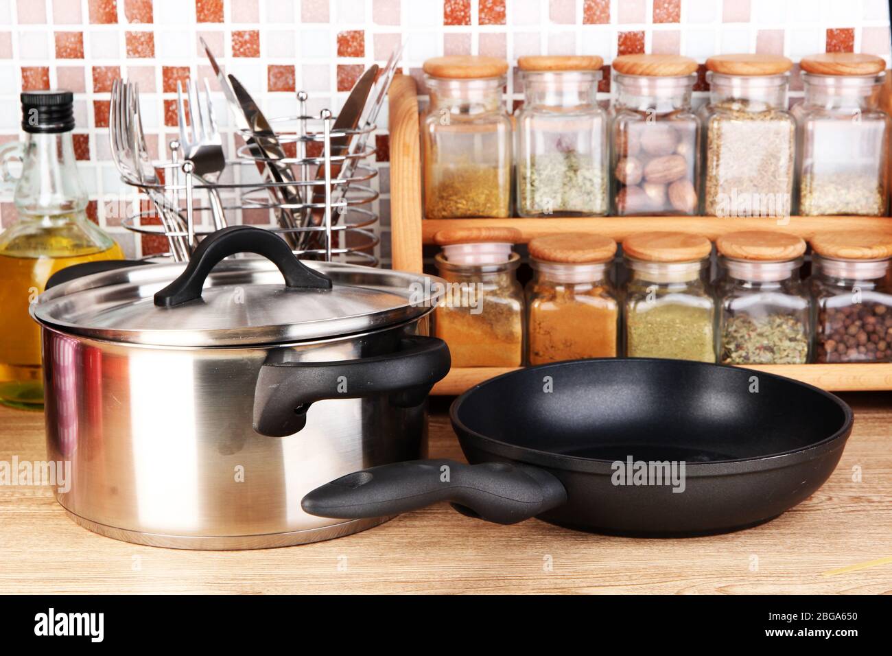 Pot and pan in kitchen on table on mosaic tiles background Stock Photo ...