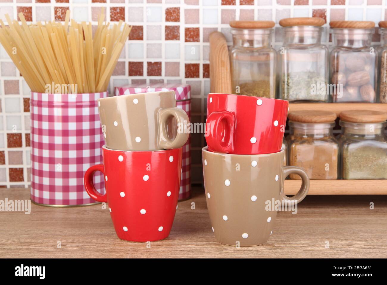 Cups in kitchen on table on mosaic tiles background Stock Photo - Alamy