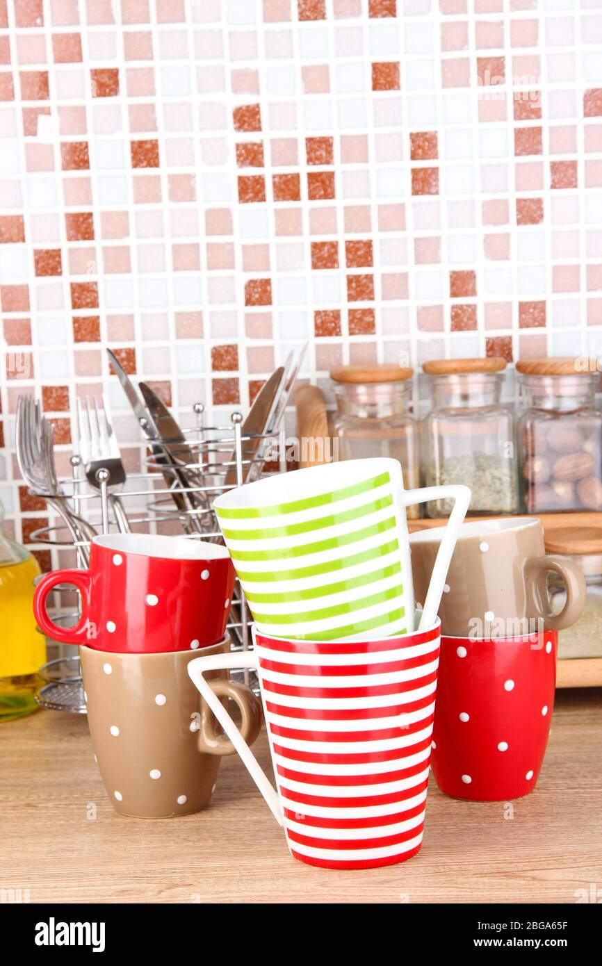 Cups in kitchen on table on mosaic tiles background Stock Photo - Alamy