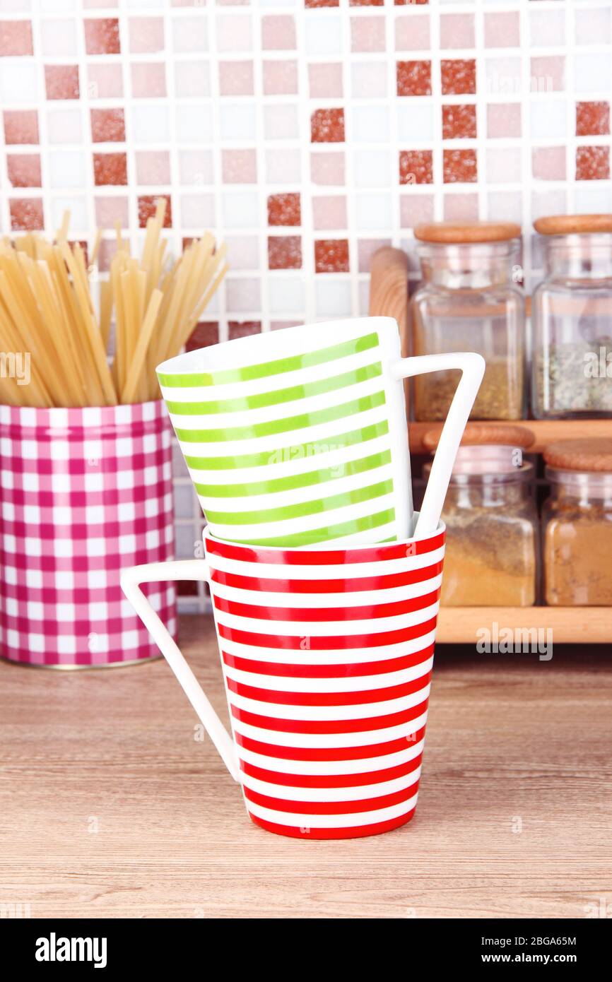 Cups in kitchen on table on mosaic tiles background Stock Photo - Alamy