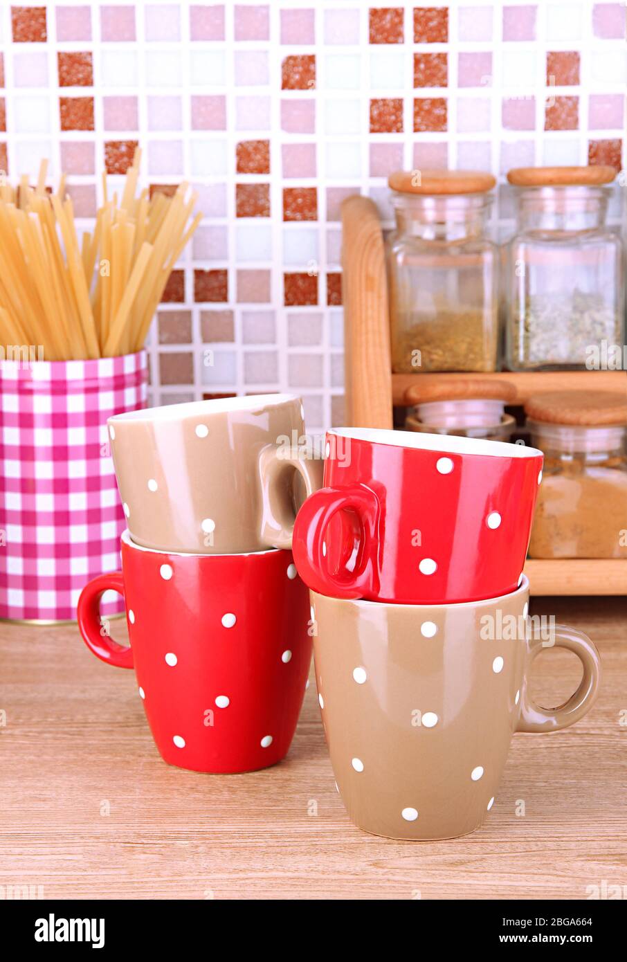 Cups in kitchen on table on mosaic tiles background Stock Photo - Alamy