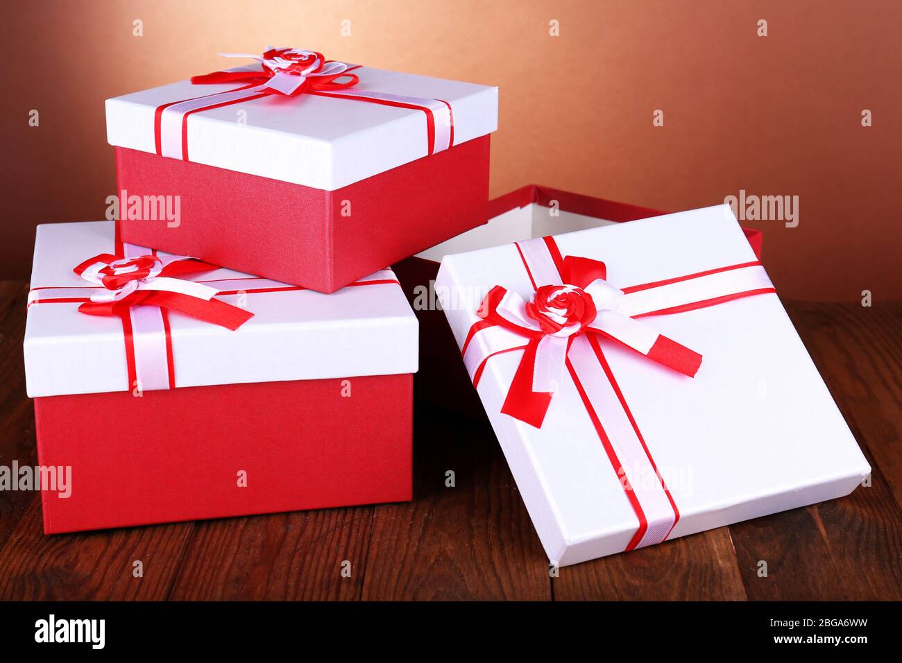 Beautiful gift boxes on table on brown background Stock Photo - Alamy