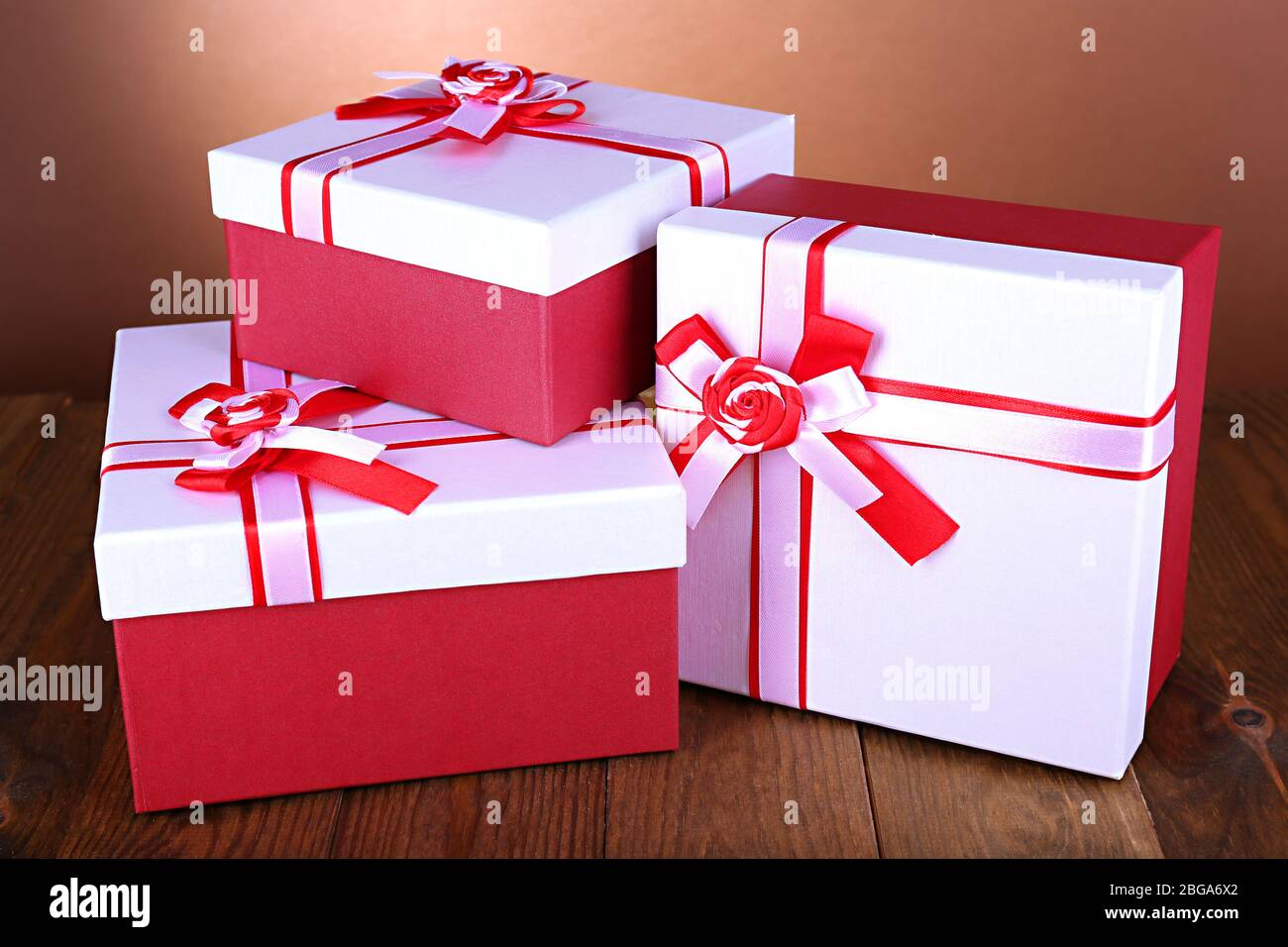 Beautiful gift boxes on table on brown background Stock Photo - Alamy