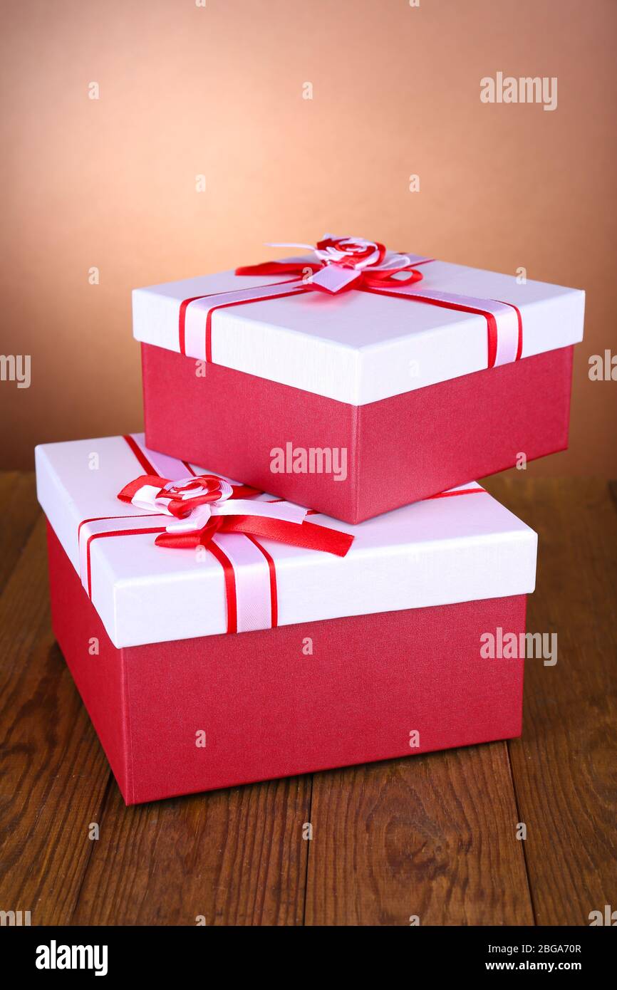 Beautiful gift boxes on table on brown background Stock Photo - Alamy