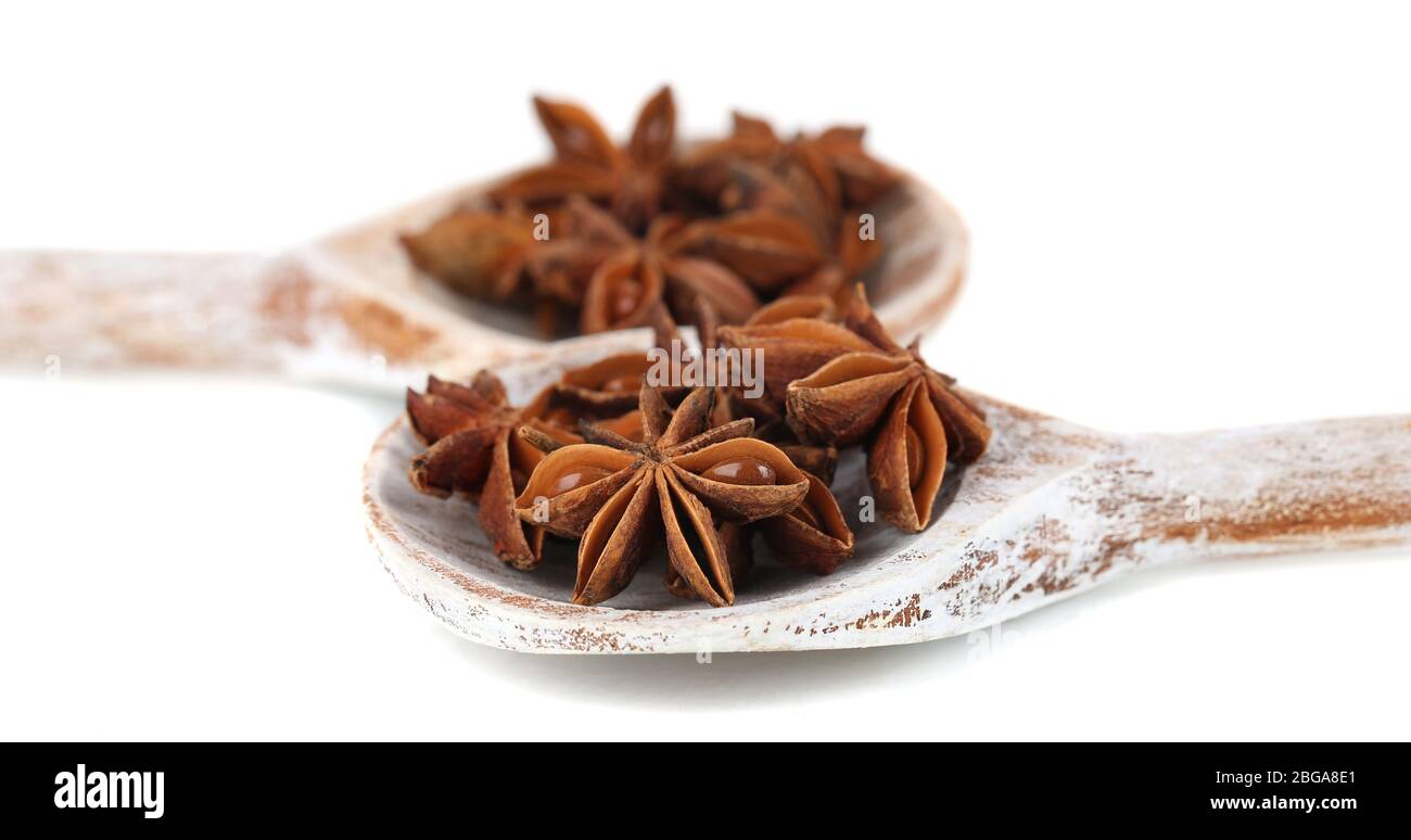 Star anise in wooden spoons, isolated on white Stock Photo - Alamy
