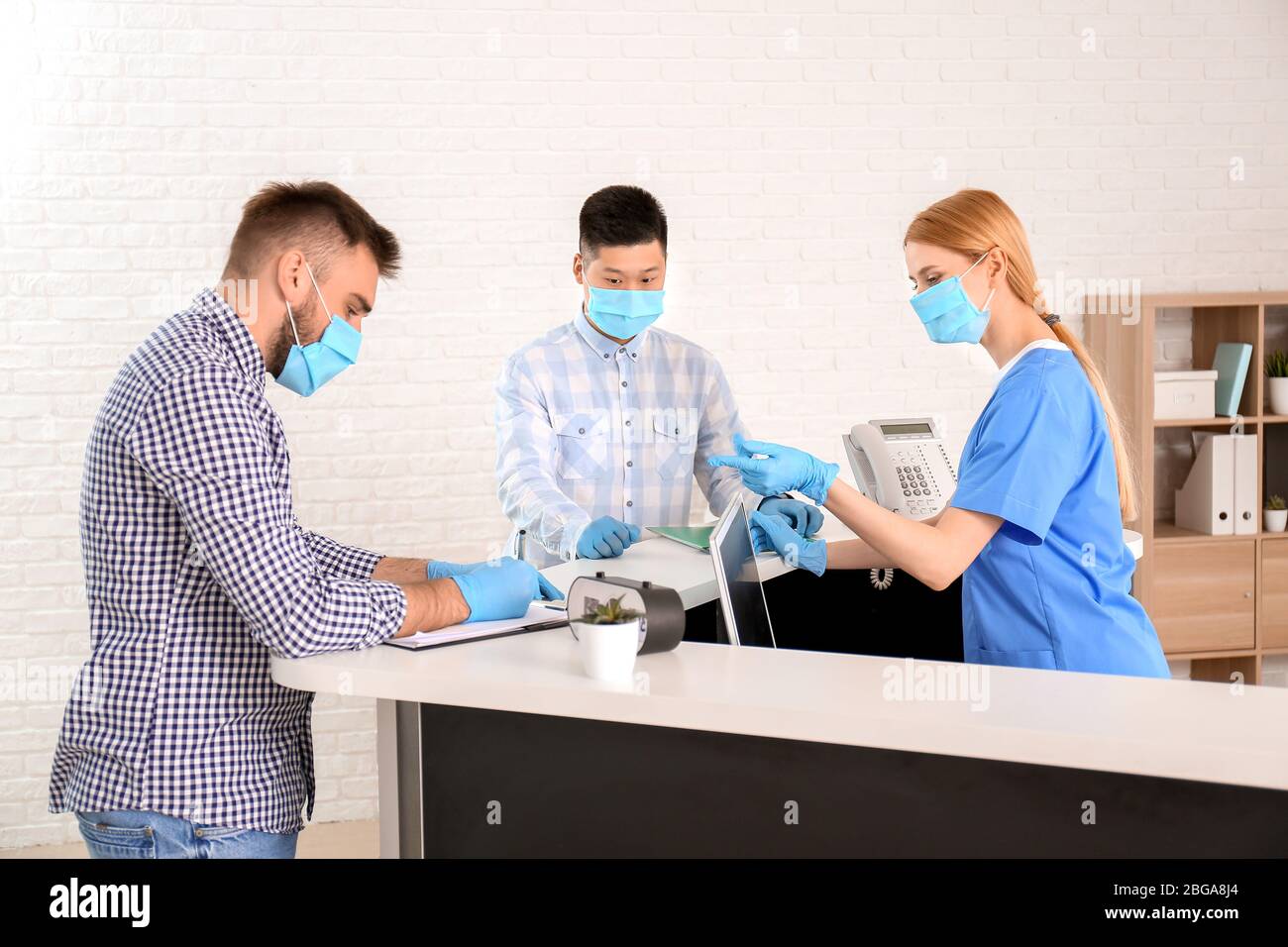 Female receptionist working with patients in clinic Stock Photo - Alamy