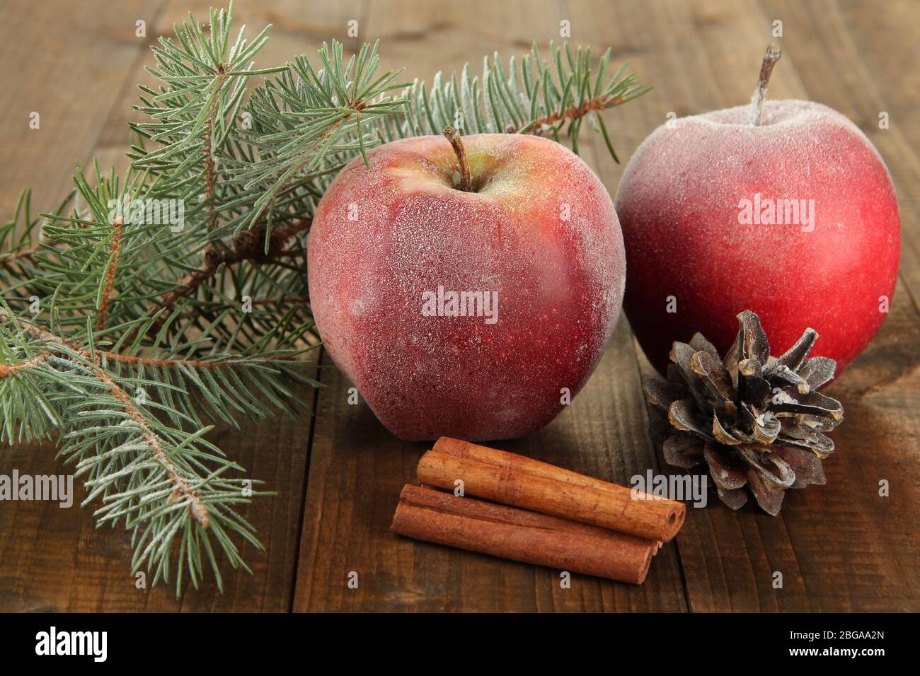 Red frosted apples with fir branch and bumps on wooden background Stock ...