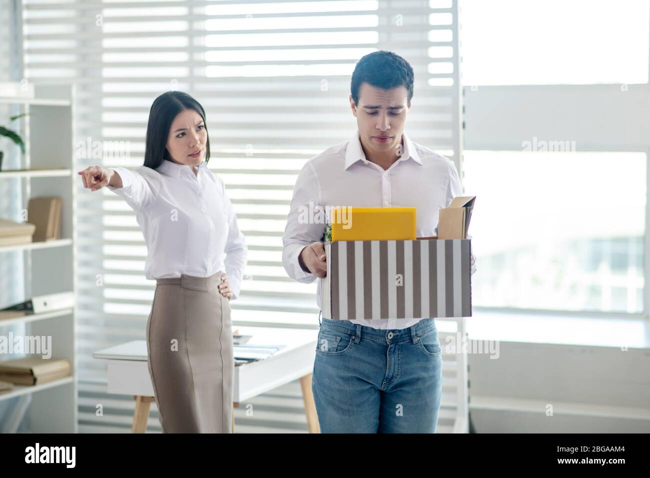 Angry manager showing to the door to her unhappy employee Stock Photo ...