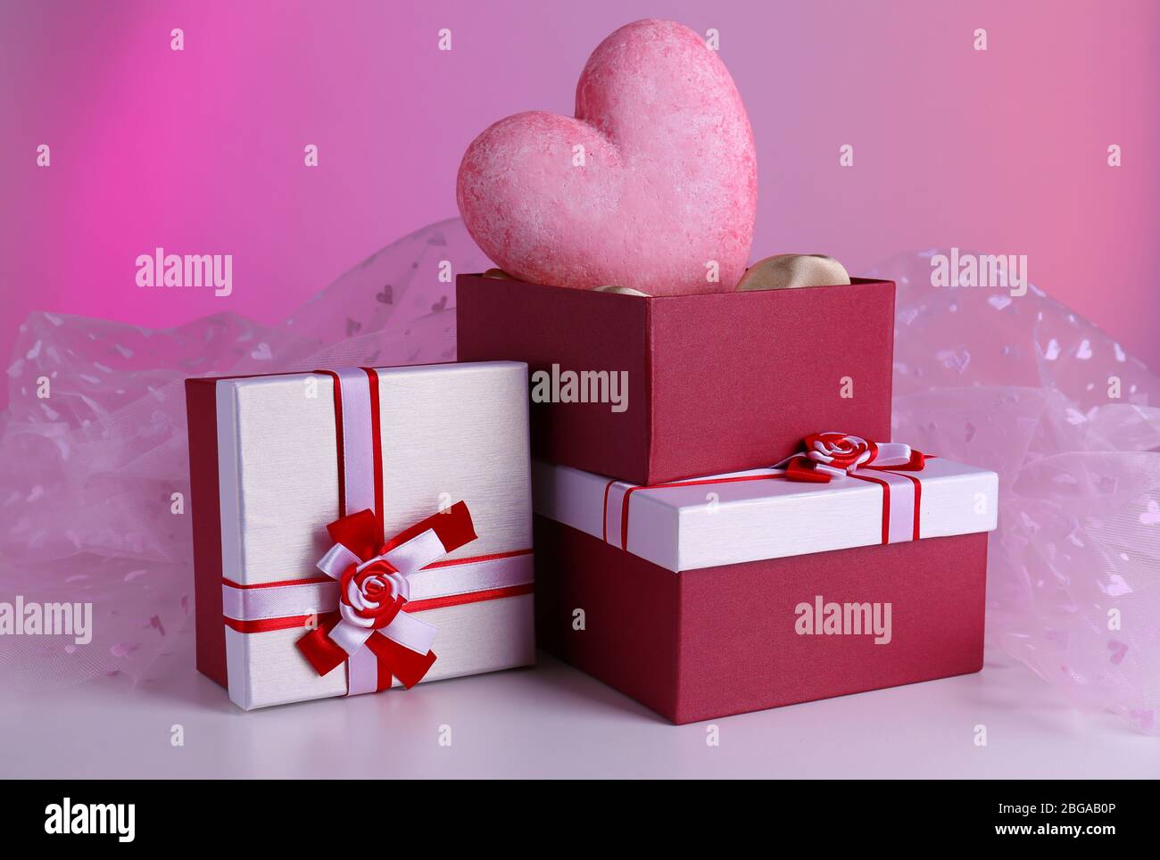 Stack of gift boxes and decorative heart, on color background Stock ...