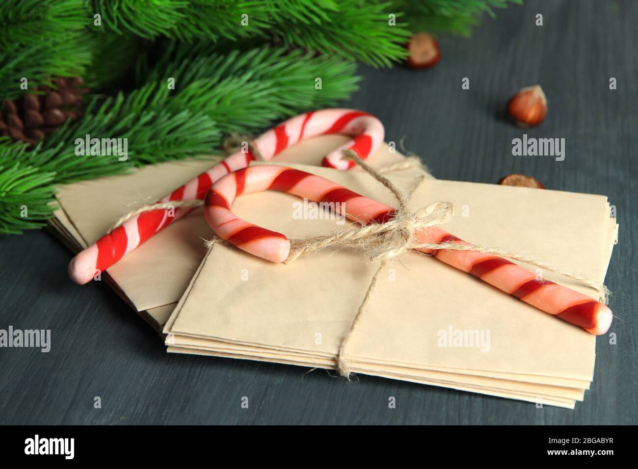 Christmas candy canes and letters for Santa, on color wooden background ...