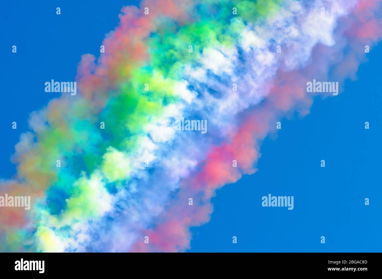 Multi colored smoke in a blue sky Stock Photo - Alamy