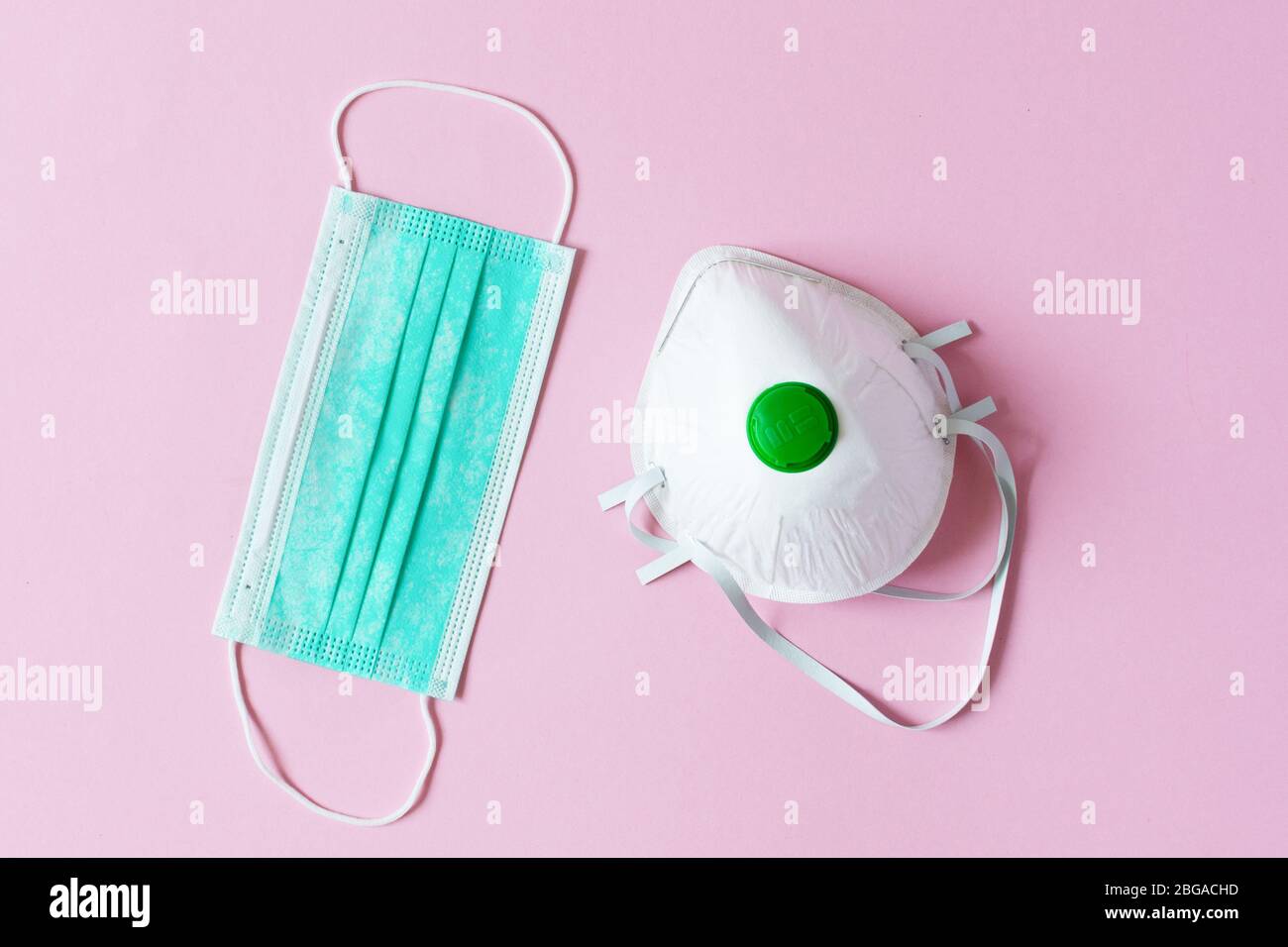 Two types of protective face masks on pink background top view ...