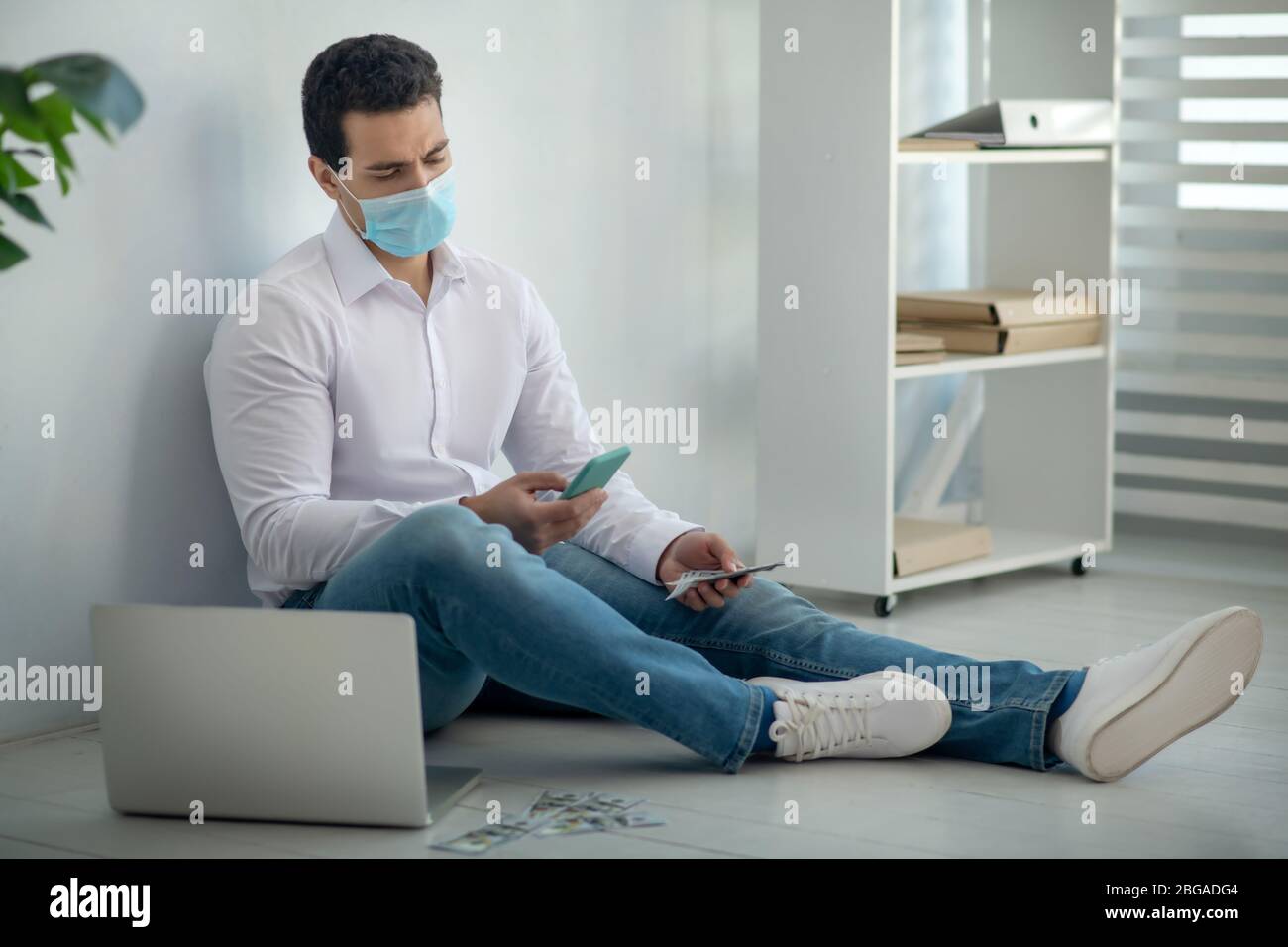 Man sitting on the floor and looking lost Stock Photo - Alamy