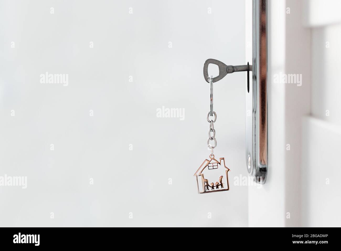 Opened door with key and metal keychain in a house shape. Door to a new ...