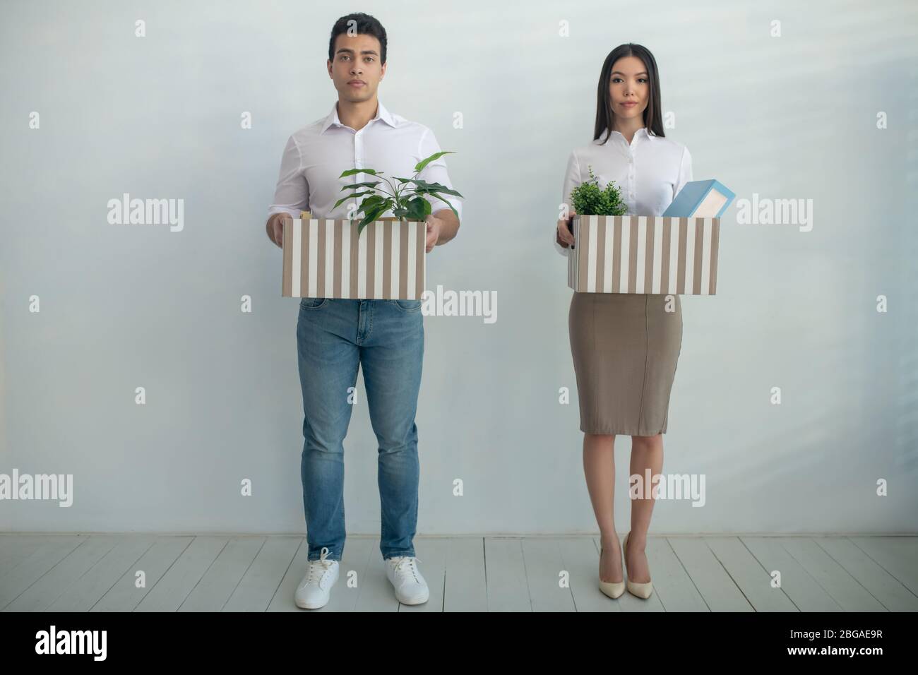 Man and woman standing with boxes in hands Stock Photo - Alamy