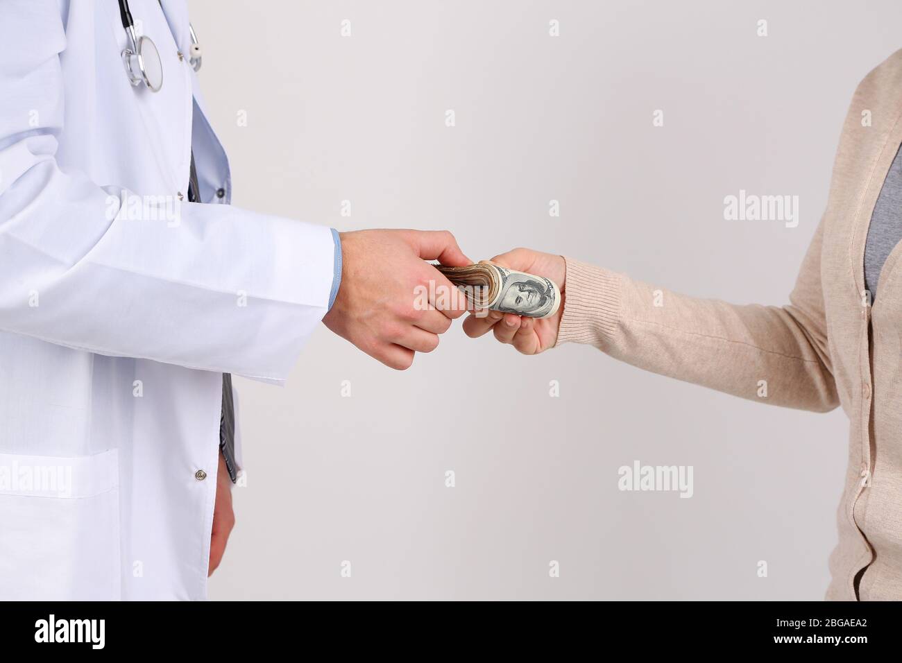 Male Doctor receiving money from patient, isolated on white Stock Photo ...