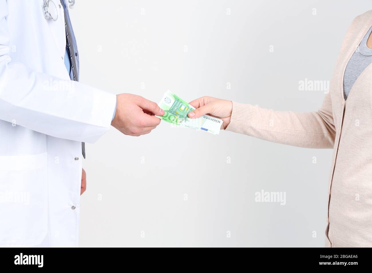 Male Doctor receiving money from patient, isolated on white Stock Photo ...