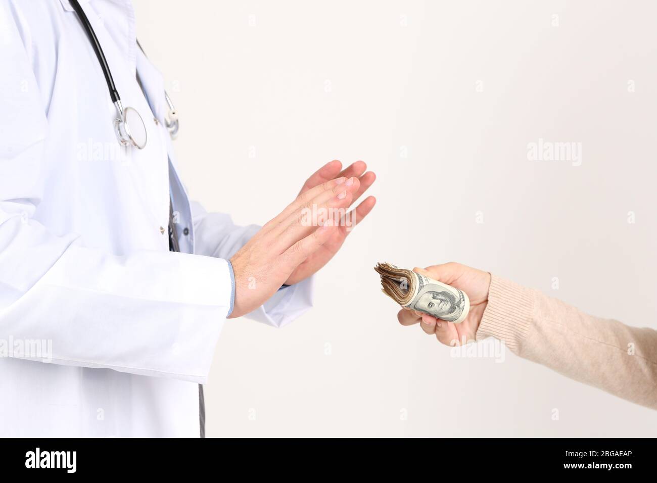 Male Doctor receiving money from patient, isolated on white Stock Photo ...