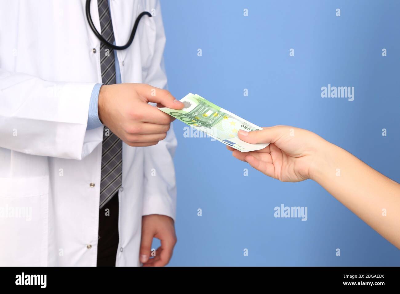 Male Doctor receiving money from patient, on blue background Stock ...