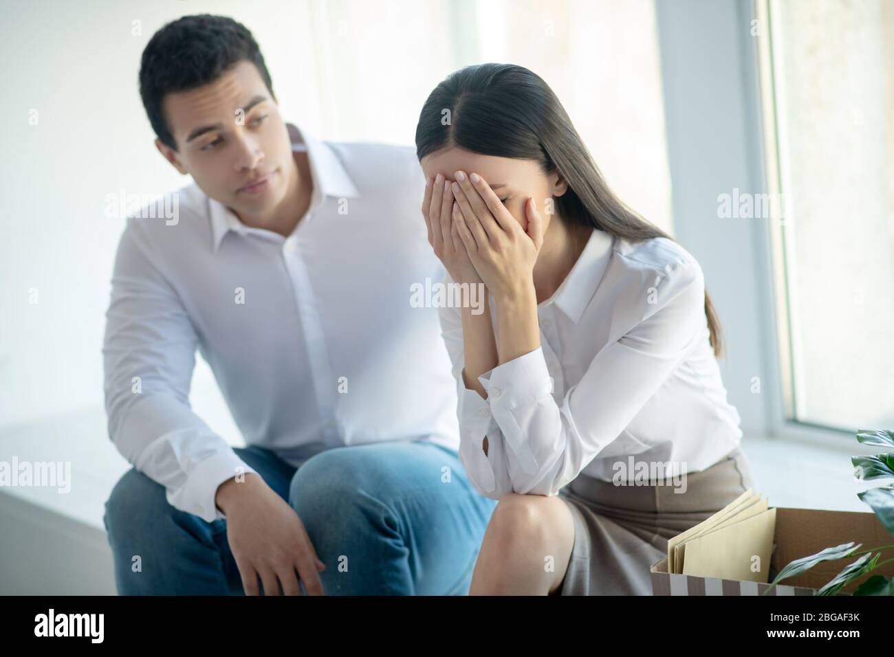 Long-haired woman in a white blouse feeling desperate Stock Photo - Alamy