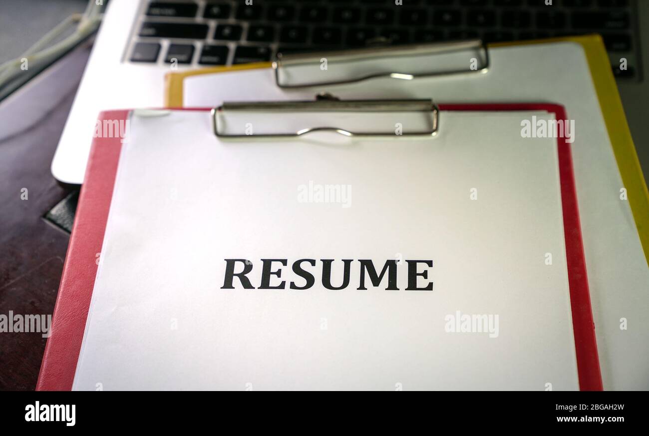 Closeup of resume on top of computer laptop on table with pen Stock ...