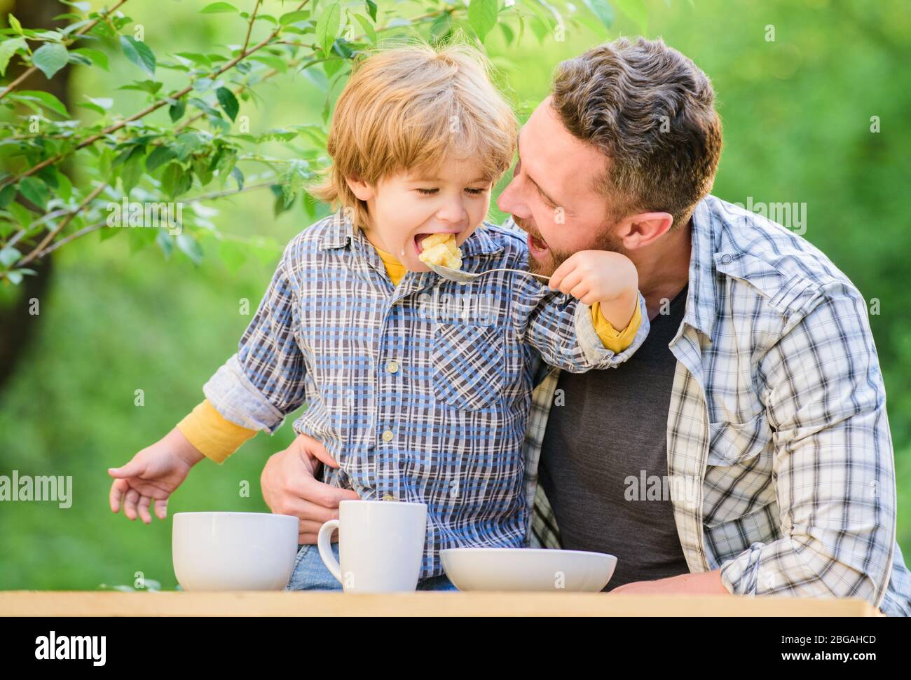 son and father eating milk porridge. Preparation of food. healthy food ...