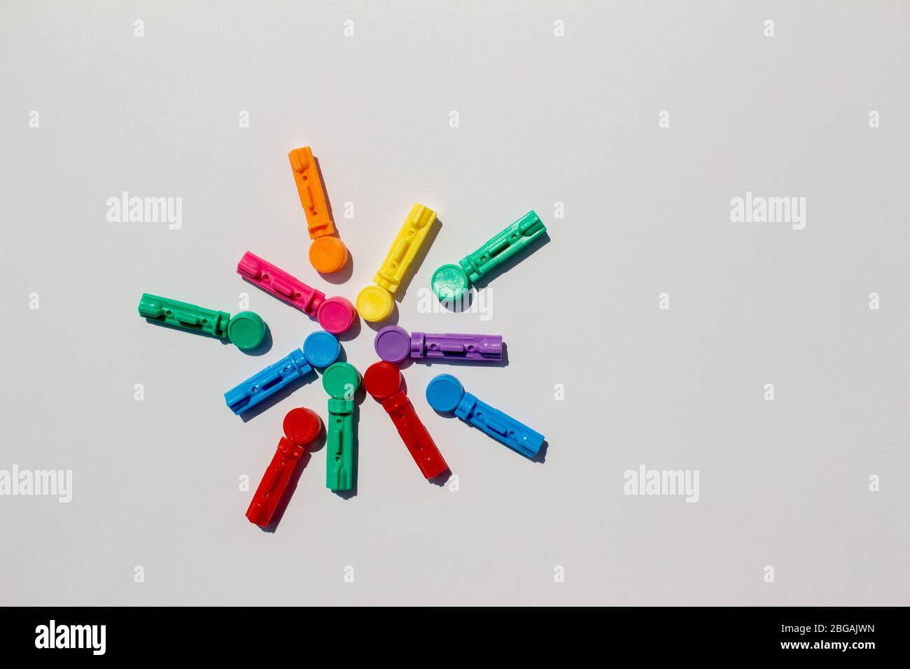 Close up abstract design of colorful glucose testing lancets on white ...