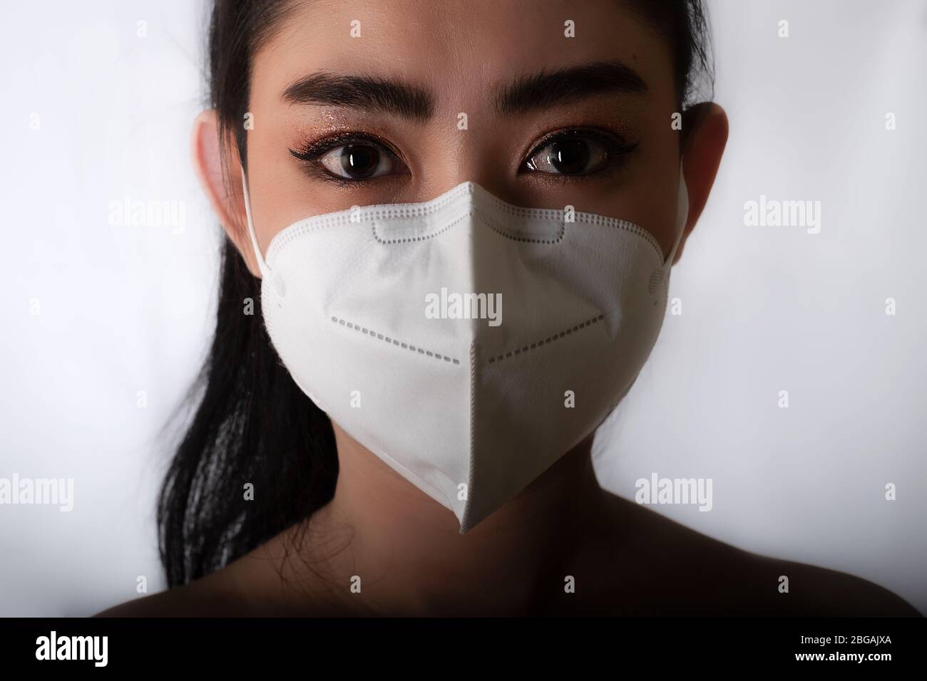 Close up of young Asia woman putting on a medical mask n95 to protect ...