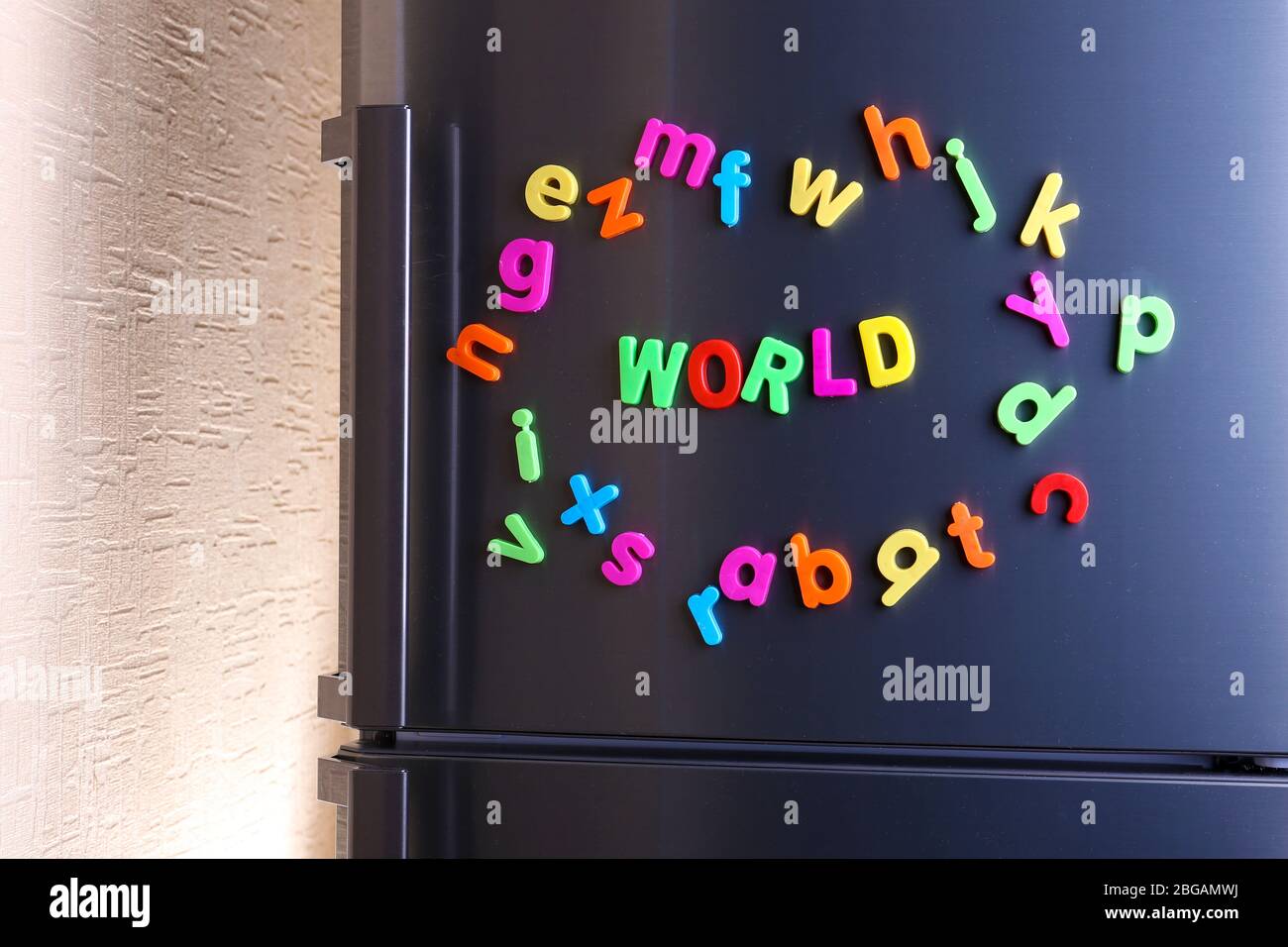 Word World spelled out using colorful magnetic letters on refrigerator ...