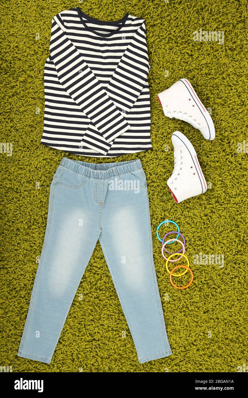 Beautiful clothes for little girl on green carpet Stock Photo - Alamy