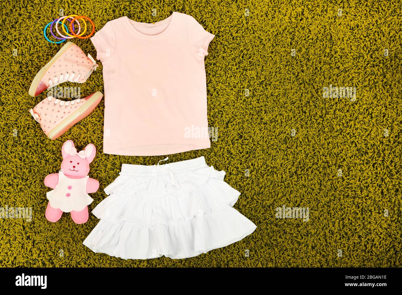 Beautiful clothes for little girl on green carpet Stock Photo - Alamy