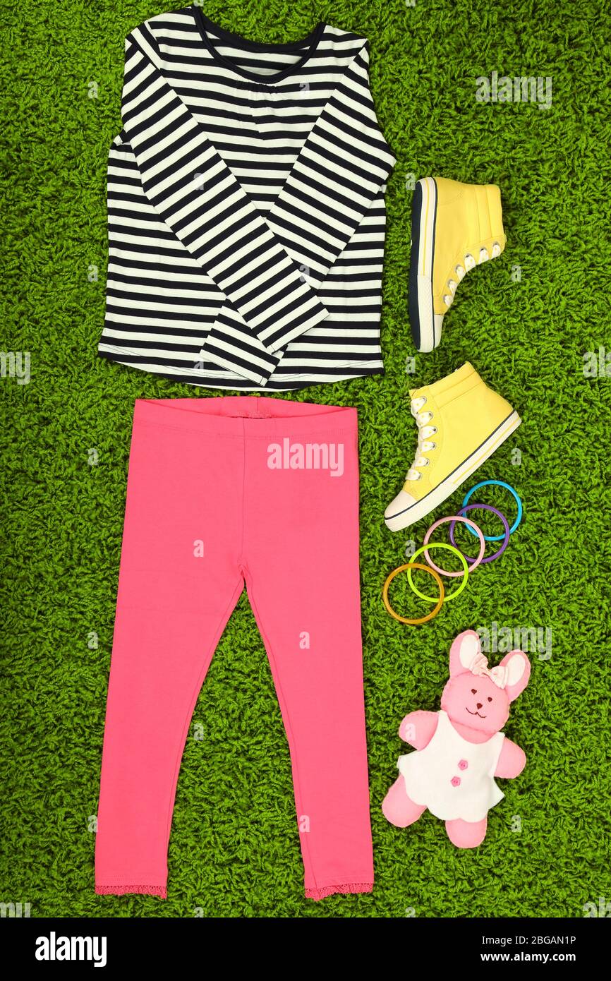 Beautiful clothes for little girl on green carpet Stock Photo - Alamy