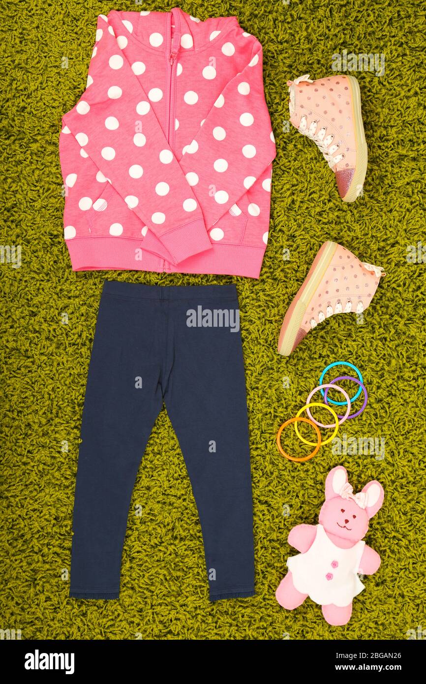 Beautiful clothes for little girl on green carpet Stock Photo - Alamy