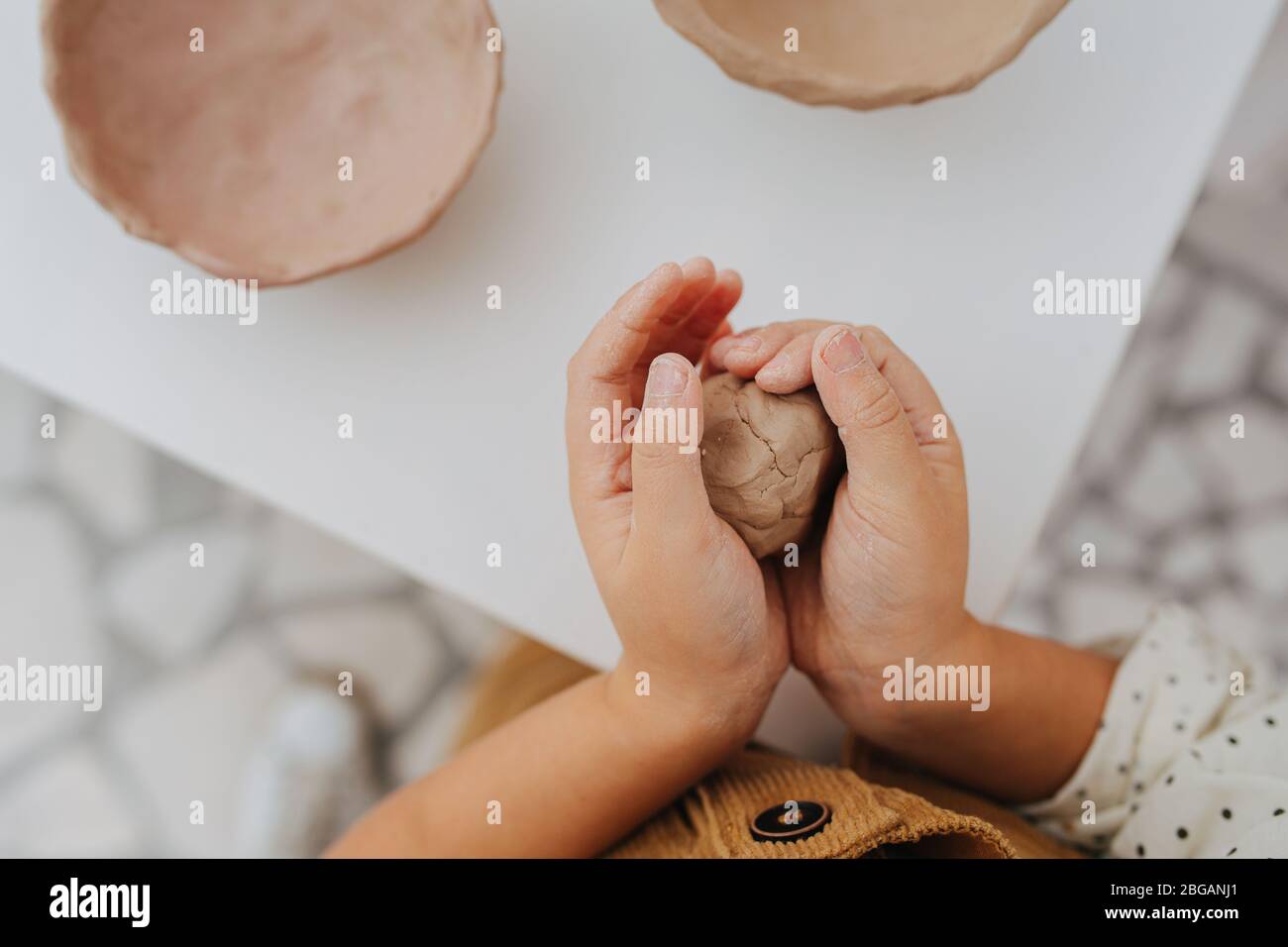 Little hands molding clay ball, close up, top view Stock Photo - Alamy