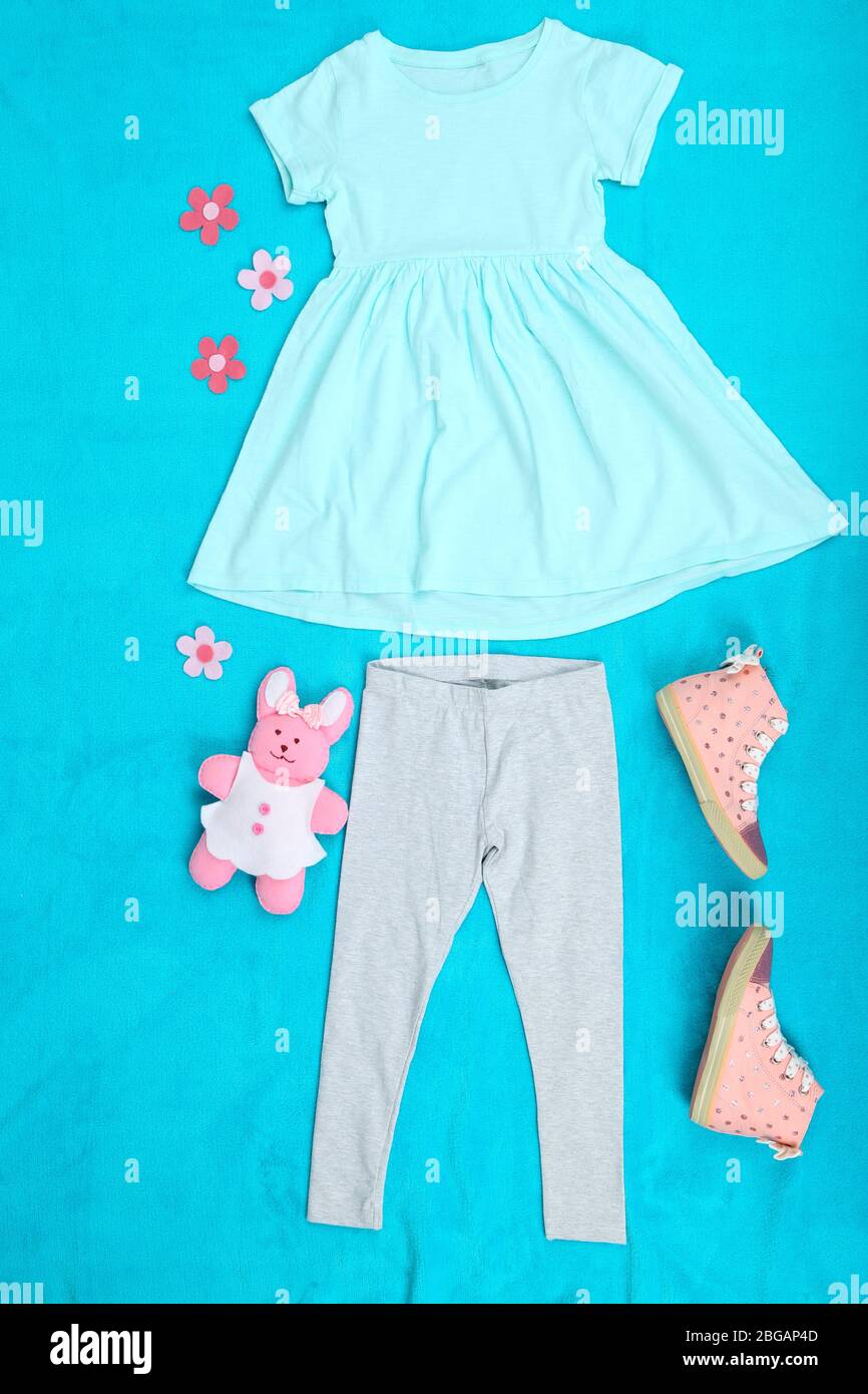 Beautiful clothes for little girl on blue background Stock Photo - Alamy