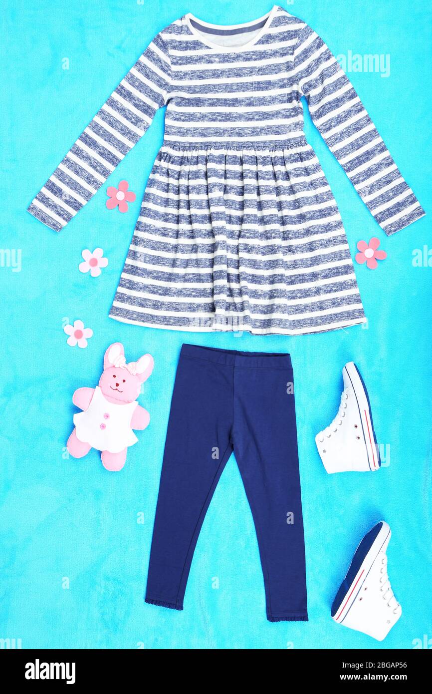 Beautiful clothes for little girl on blue background Stock Photo - Alamy