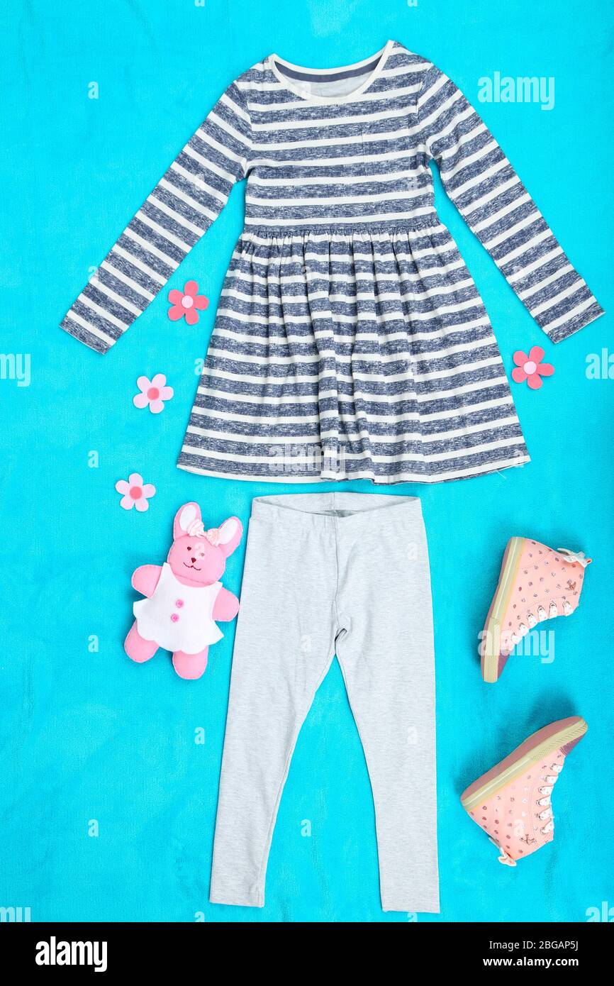 Beautiful clothes for little girl on blue background Stock Photo - Alamy