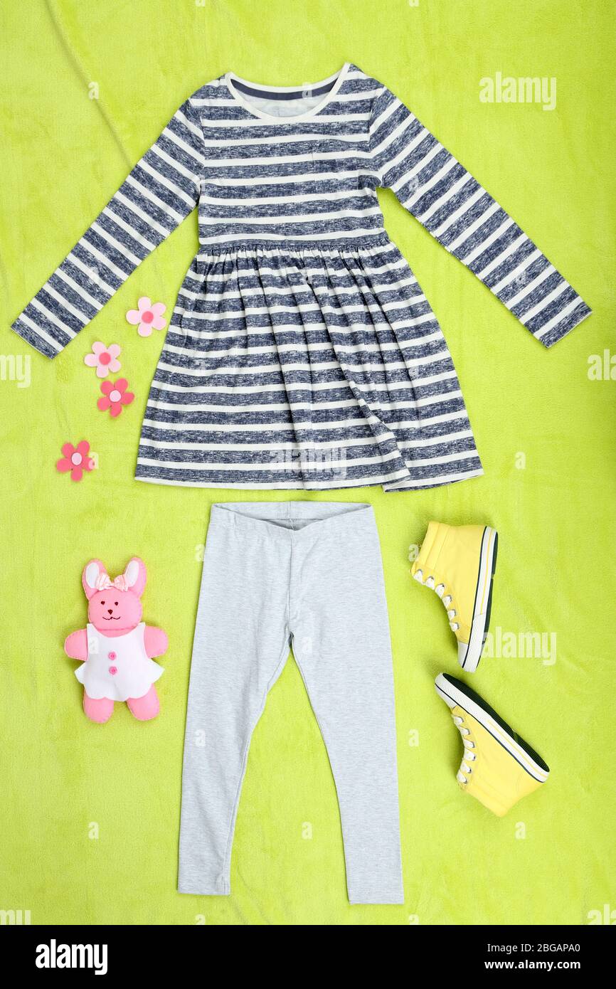 Beautiful clothes for little girl on green background Stock Photo - Alamy