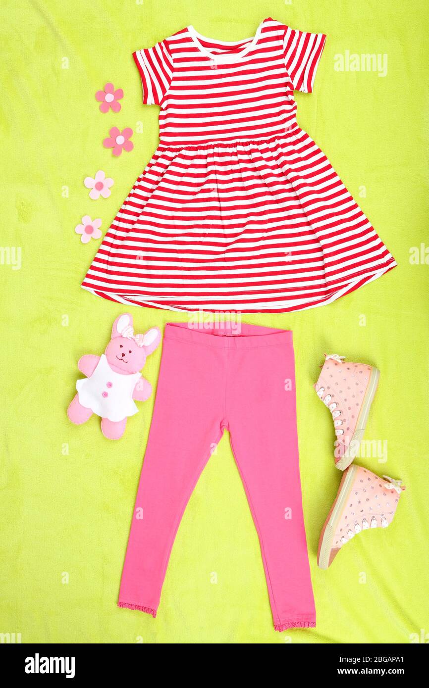 Beautiful clothes for little girl on green background Stock Photo - Alamy