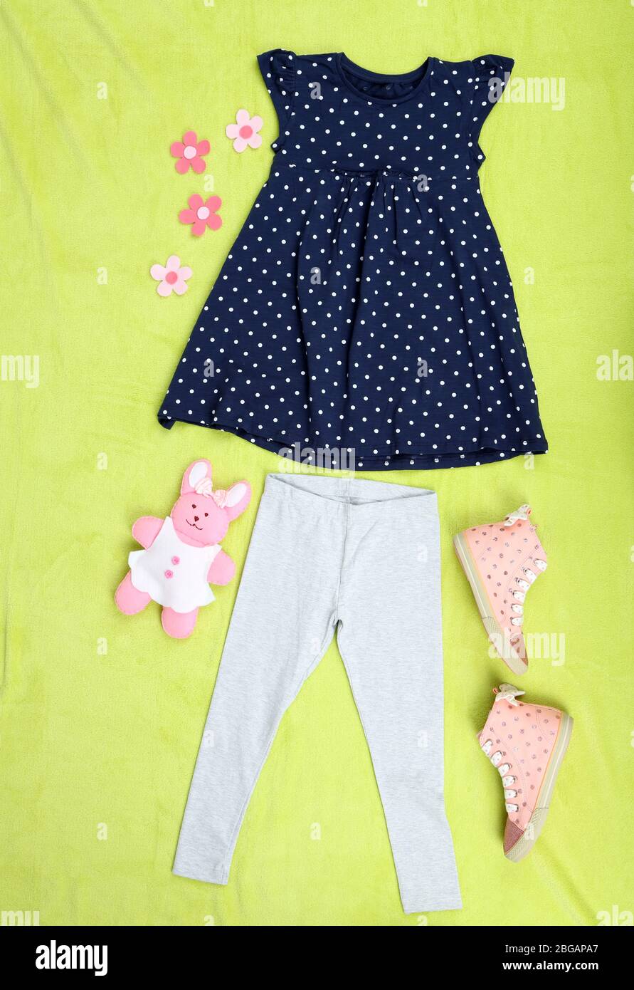 Beautiful clothes for little girl on green background Stock Photo - Alamy