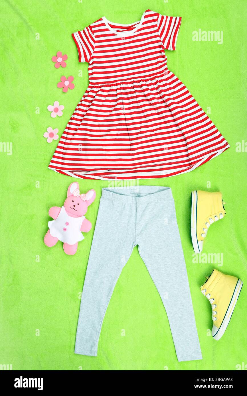Beautiful clothes for little girl on green background Stock Photo - Alamy
