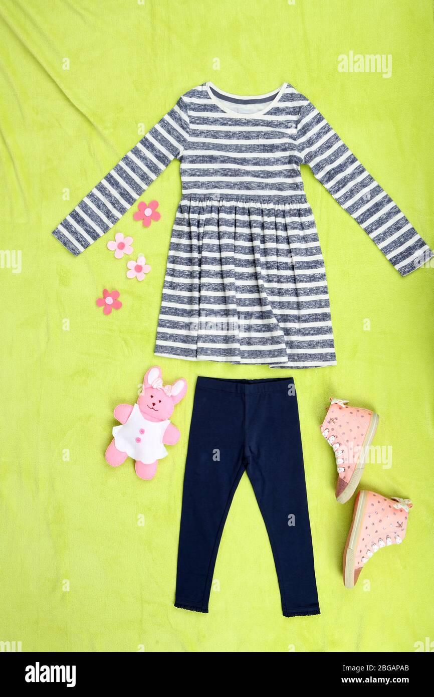 Beautiful clothes for little girl on green background Stock Photo - Alamy