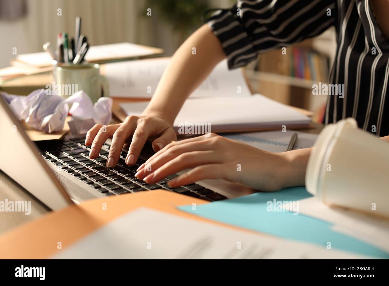 Close up of messy entrepreneur hands working on laptop on a ...