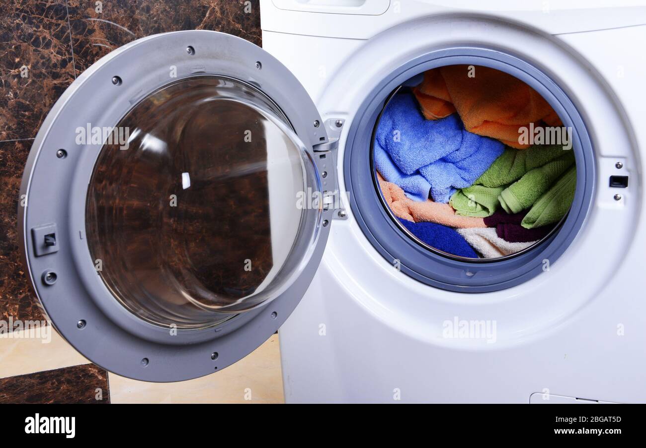 Washing machine loaded with clothes close-up Stock Photo - Alamy