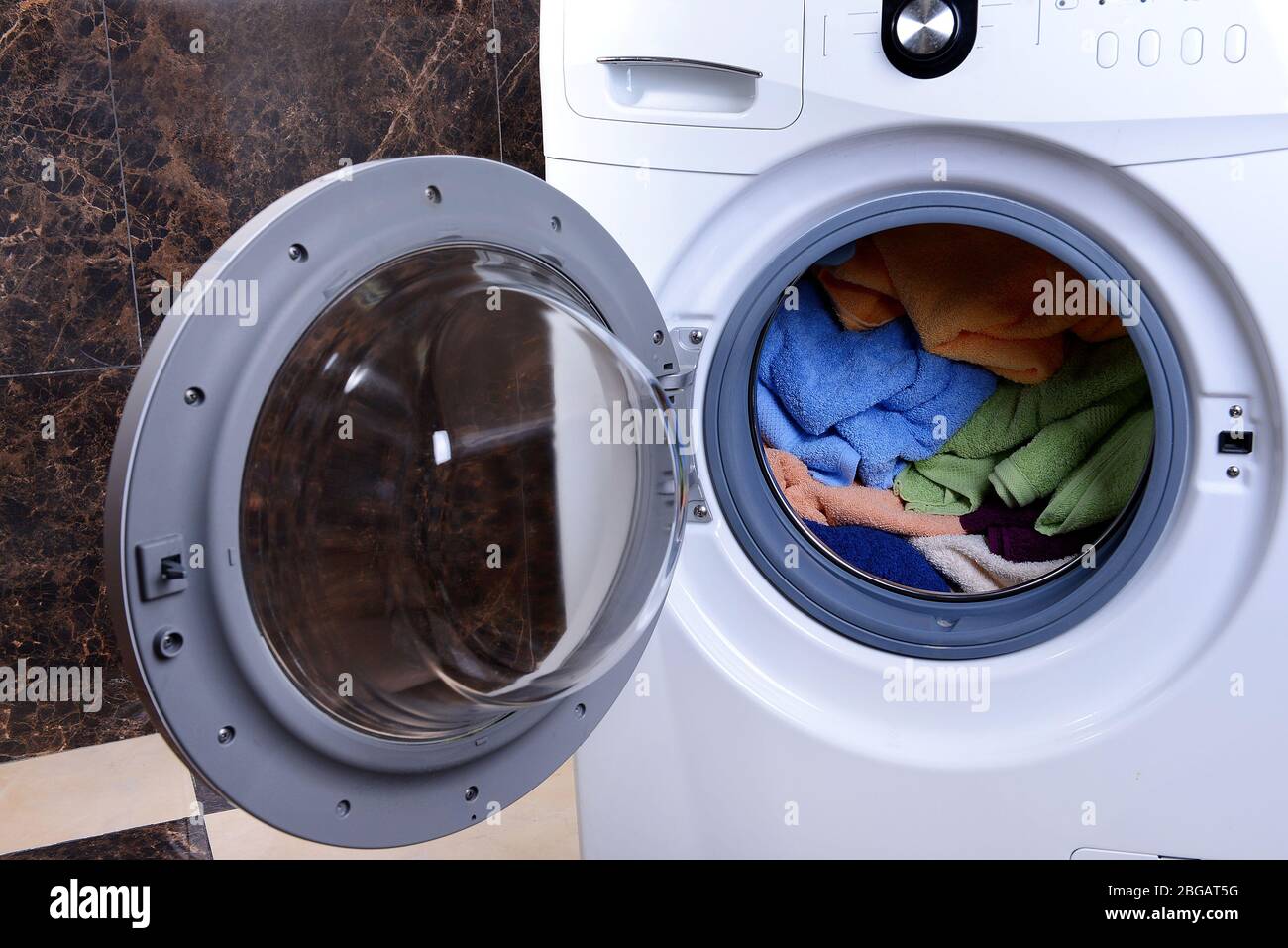 Washing machine loaded with clothes close-up Stock Photo - Alamy
